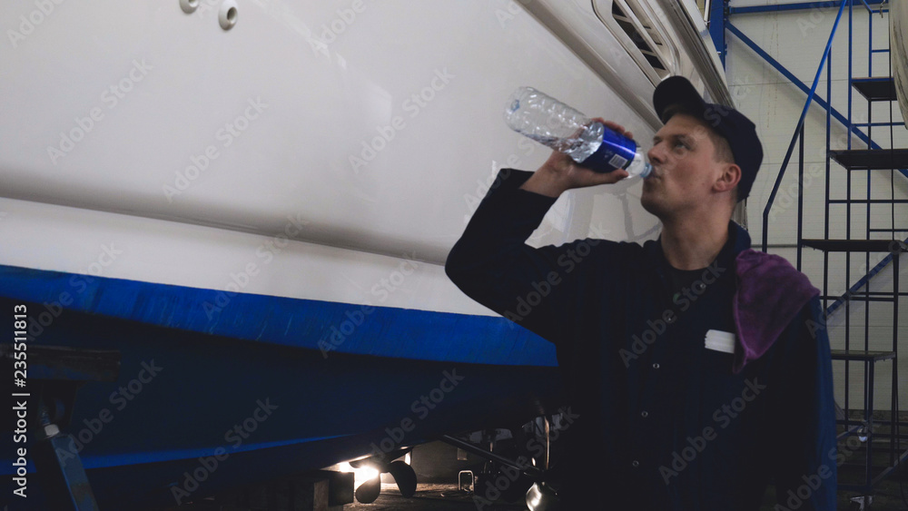 Young portrait guy (male) worker (engineer) in the garage of yachts in ...