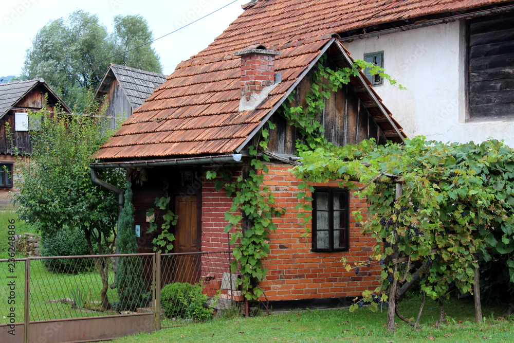 Very small red bricks garden house with wooden doors and window frame ...