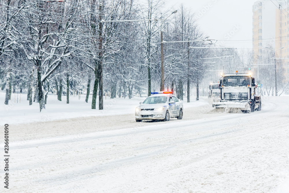 Convoy with patrol police car of snow trucks shoveling snow from the ...