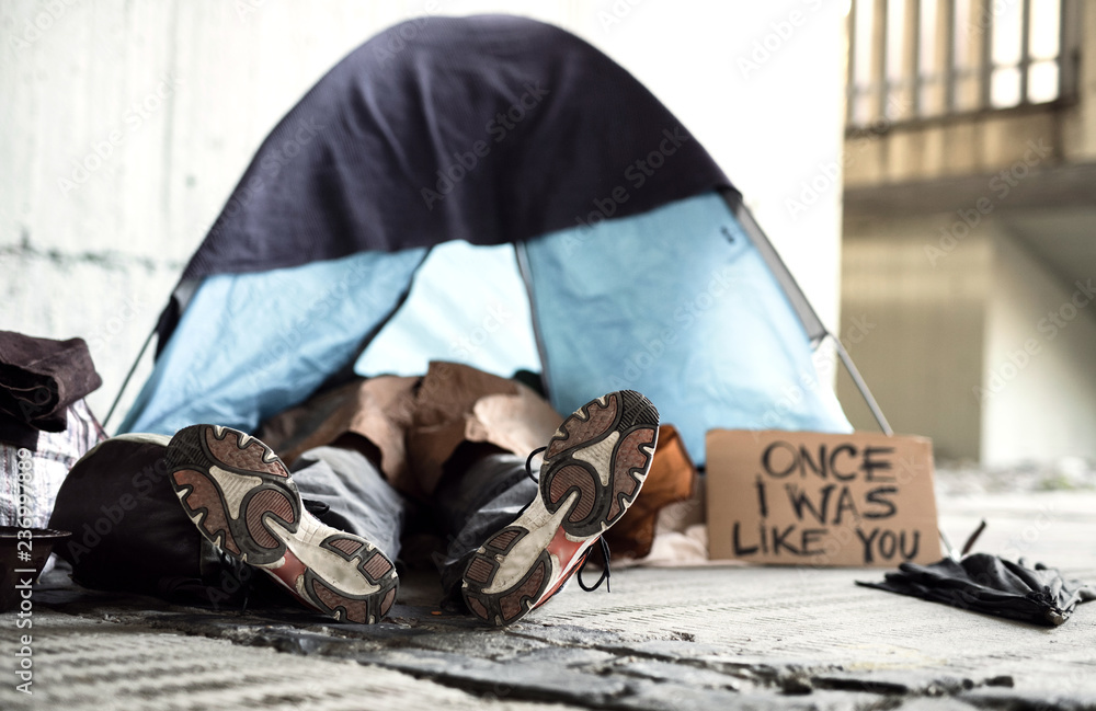 Legs and feet of homeless beggar man lying on the ground in city ...