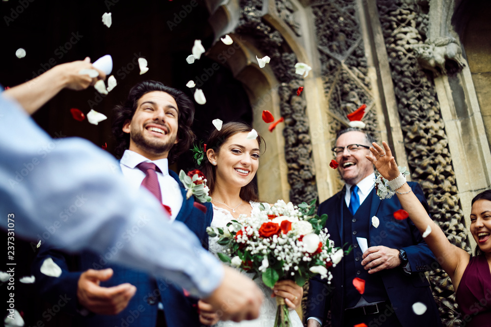 Family throwing rose petals at the newly wed bride and groom の Stock ...