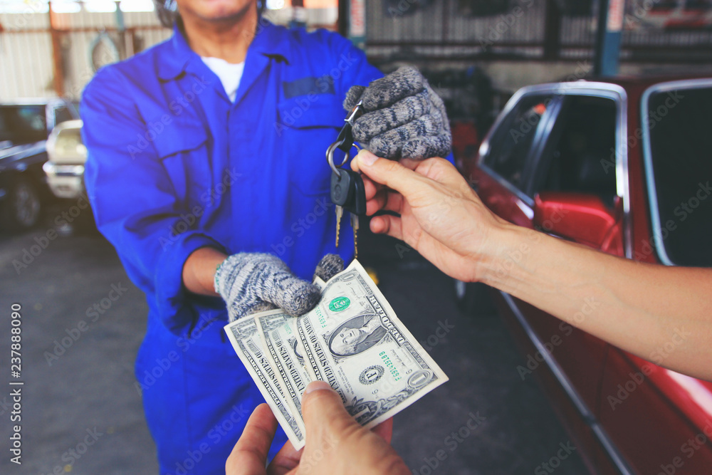 Man handed the money to Car mechanic holding in a hand car keys, car ...