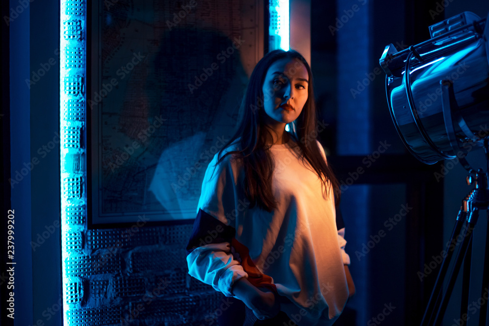 attractive fit girl looking aside while standing near the light. close ...