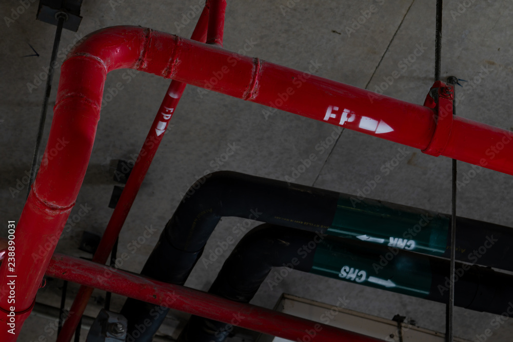 Fire sprinkler system with red pipes hanging from ceiling inside ...