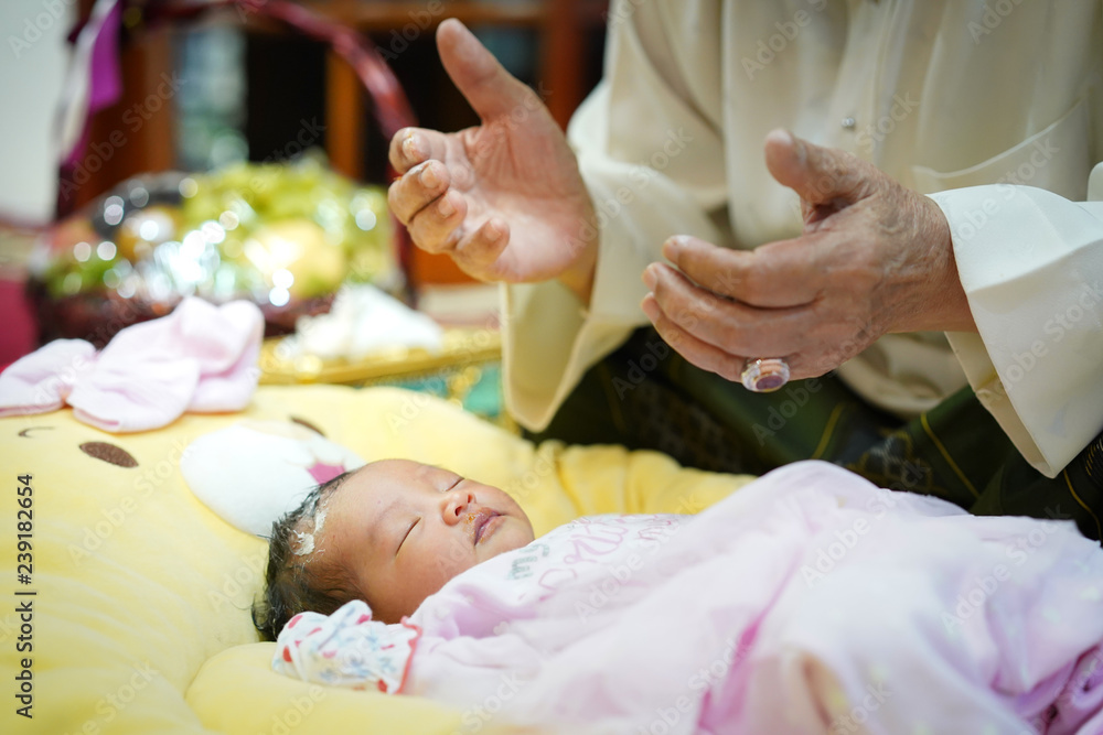 Indonesian muslim man pray for his baby. this kind of activity or rite ...