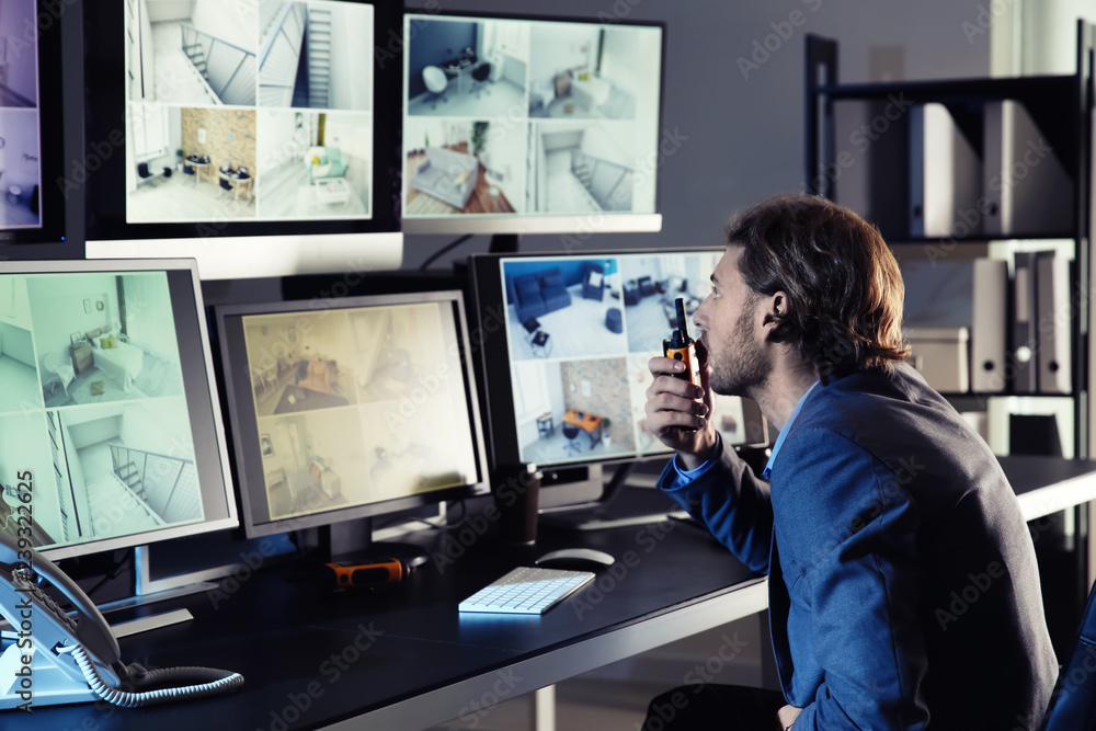 Security guard monitoring modern CCTV cameras in surveillance room ...