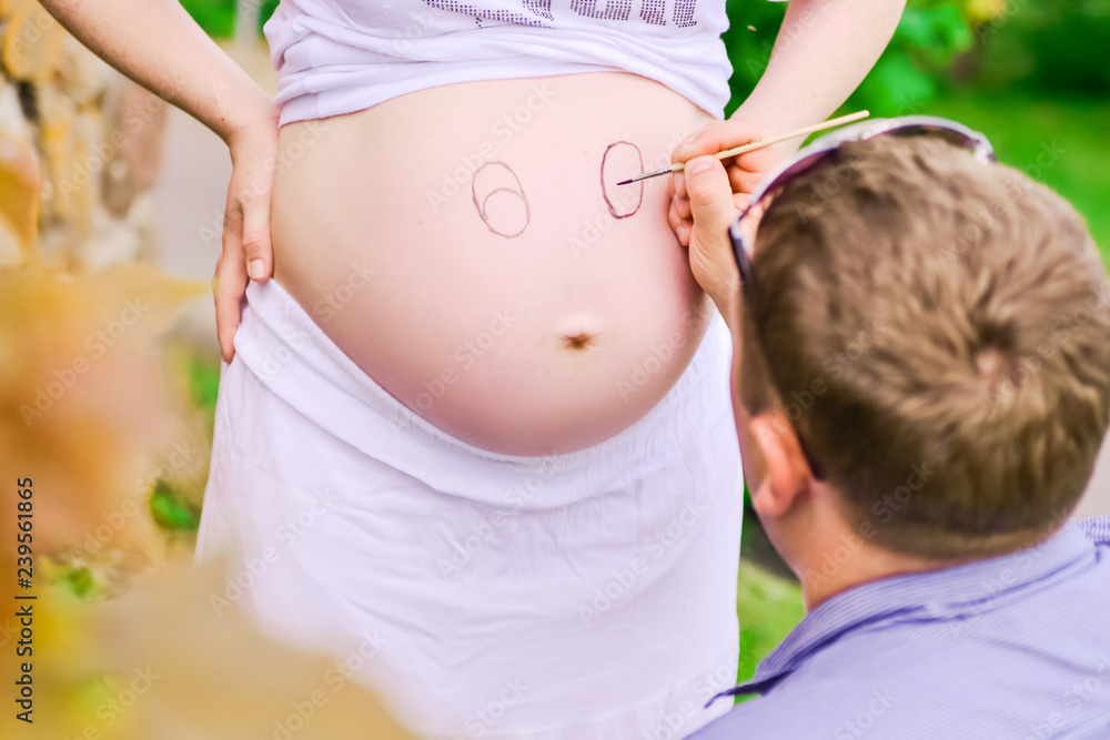 Happy smiley face painting on the belly of pregnant woman. Concept ...