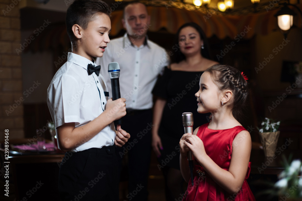 Foto de Stock Brother and sister sing karaoke songs in microphones, and ...