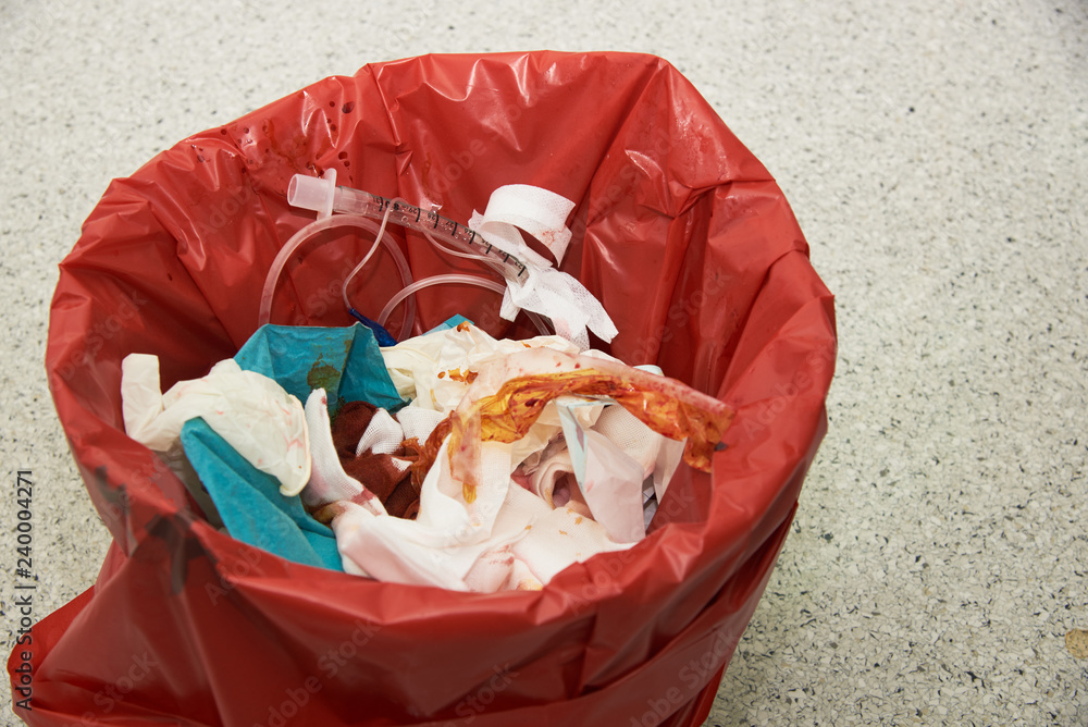 Used endotracheal tube, surgical gloves stained with blood in a red ...