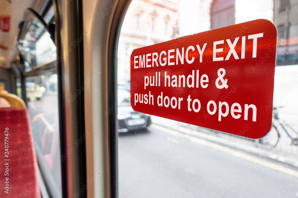 Red emergency exit door sign on the back of the public bus for open in ...