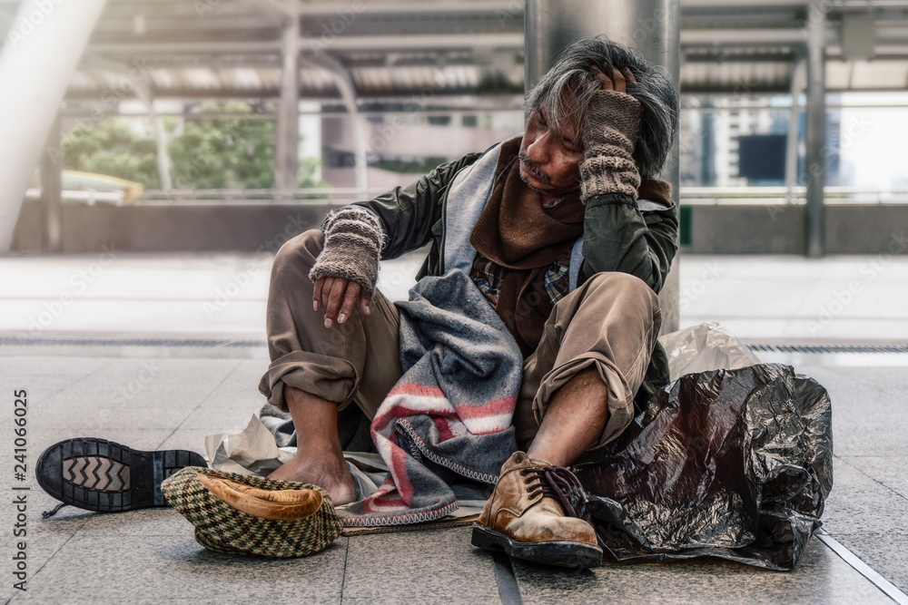 Foto de Stock poor homeless beggar sitting on pathway in suffering manner | Adobe Stock