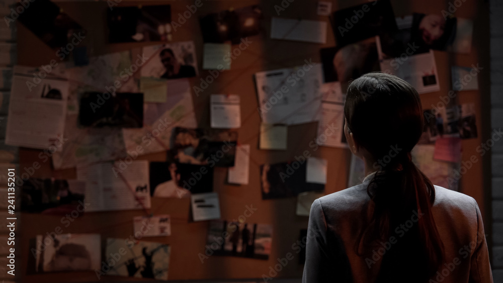 Lady private agent looking at crime investigation board, chasing serial ...