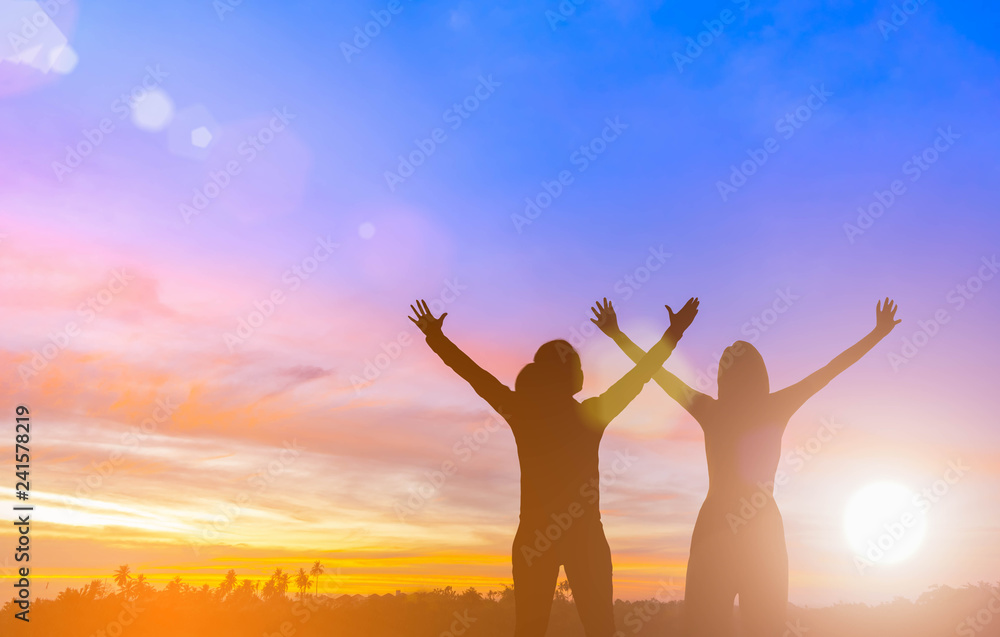 Two happy successful women raising arms toward beautiful scenery ...