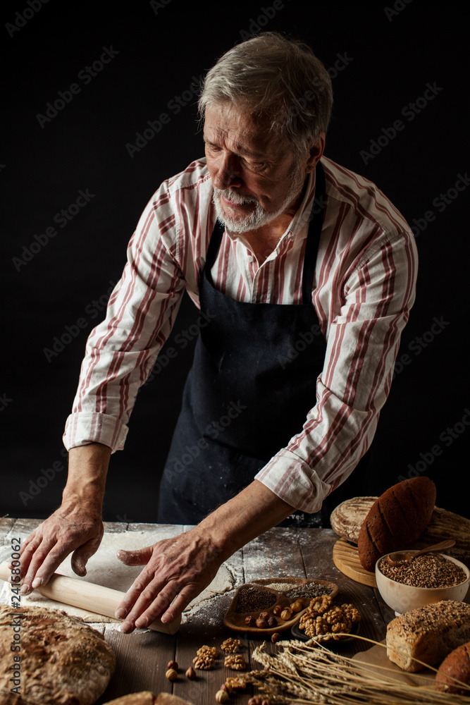 Positive mature bearded Man singing a song while baking bread in the ...