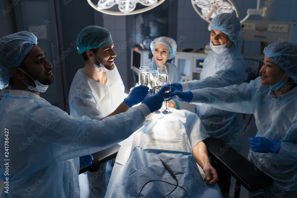 Fotografie Happy diverse team of surgeons toasting with oxygen cocktail ...