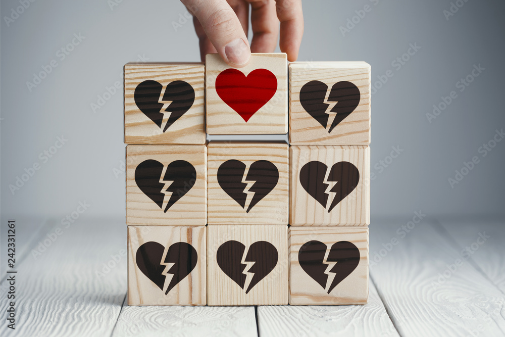 Hand putting the cube with a red heart symbol, which is opposite to ...