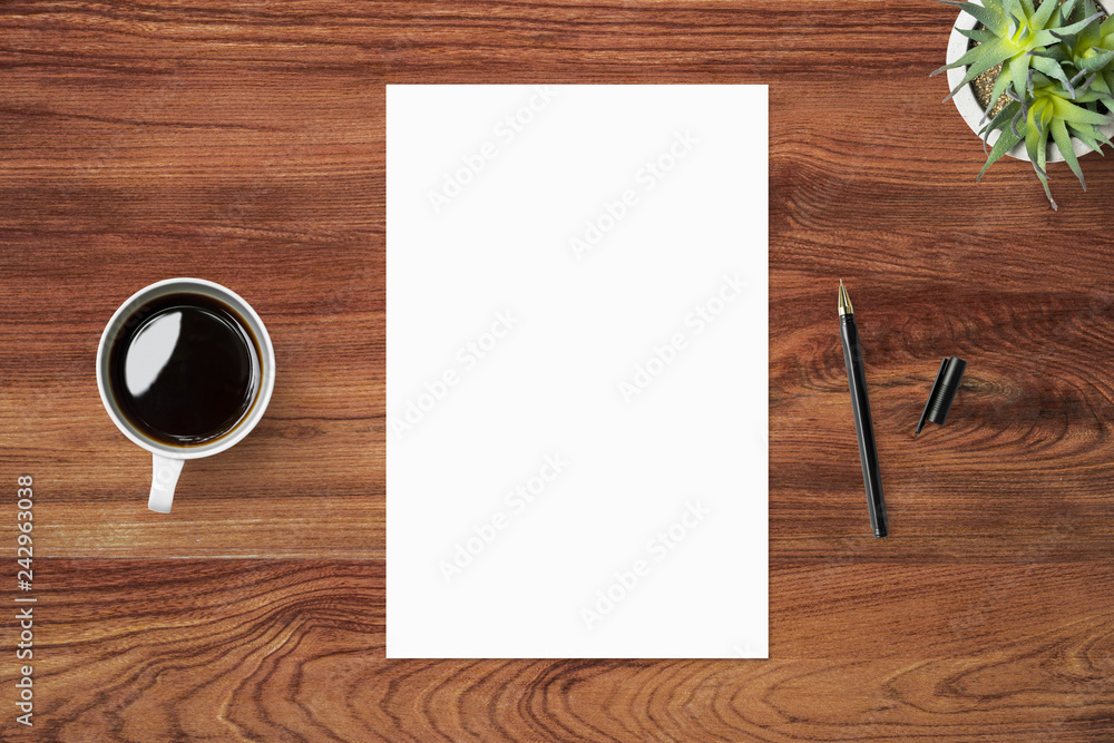 Blank a4 paper is on top of wood office desk table with supplies. Top ...