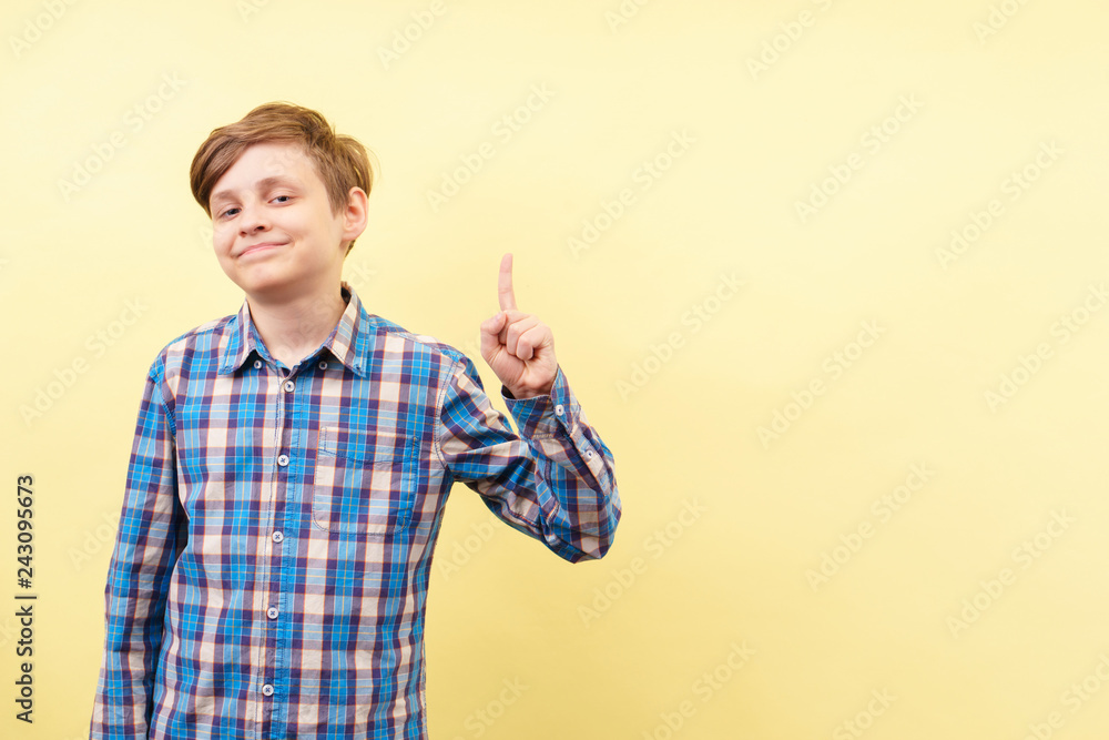grinning boy pointing to object or text. advertisement or product ...