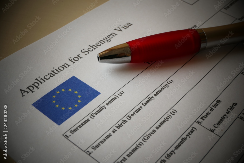 EU Schengen Visa application form with a pen for filling out. Document ...