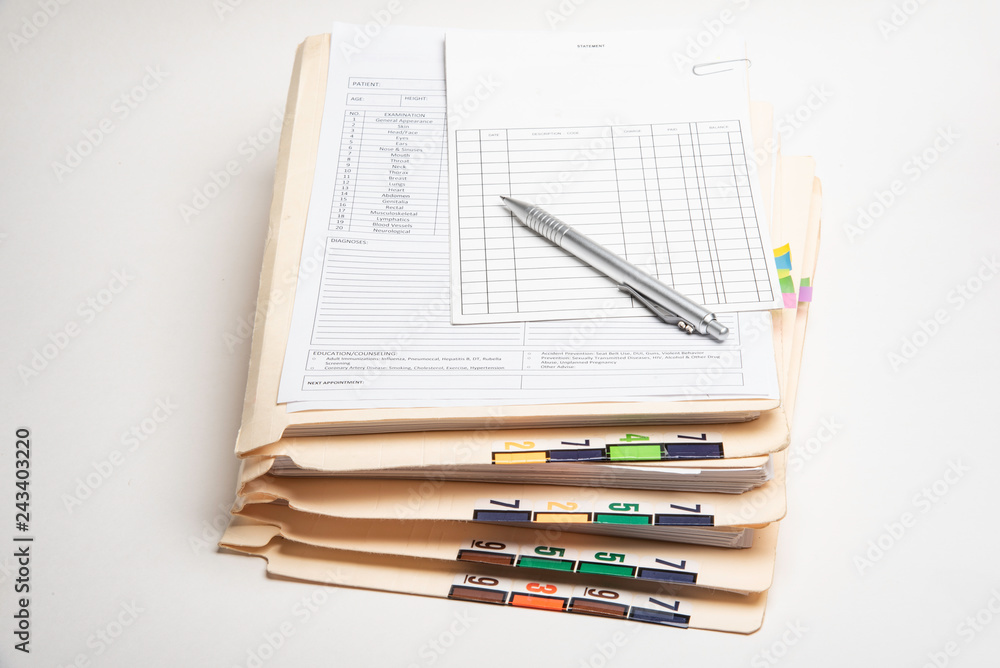 A stack of color-coded and numbered patient medical records with blank ...