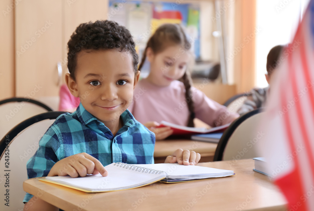 Cute African American boy doing homework in classroom at school Stock ...