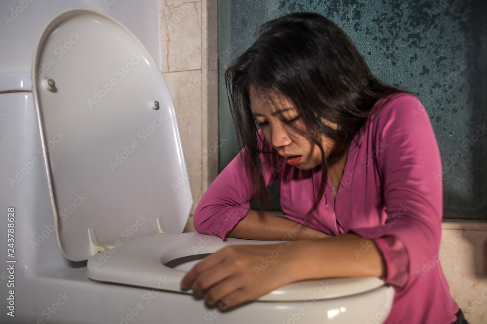 young drunk or pregnant Asian woman vomiting and throwing up in toilet ...