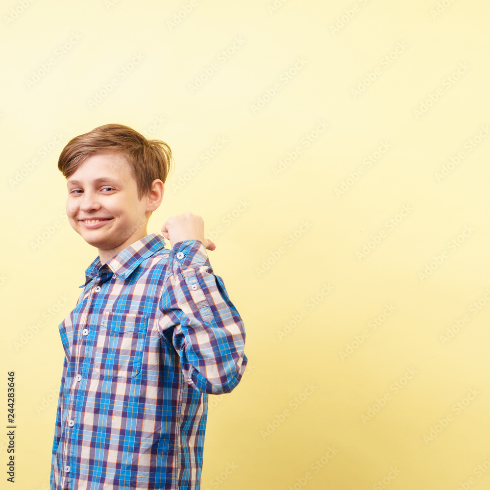 smiling boy pointing to object or text behind his back. advertisement ...