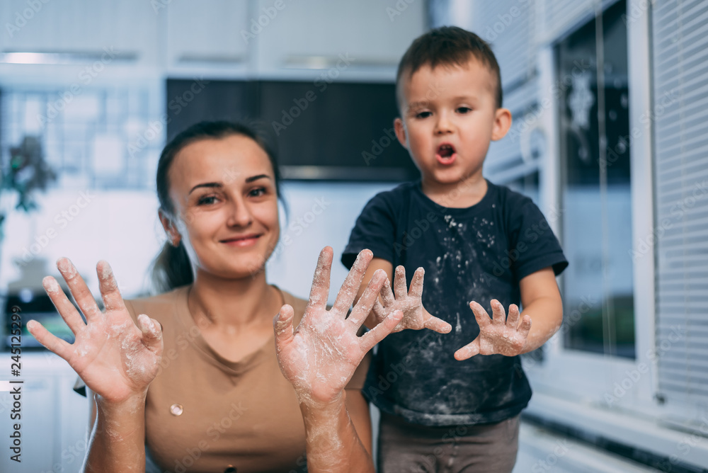mom and son cook dough and flour fun dirty in the kitchen showing off ...