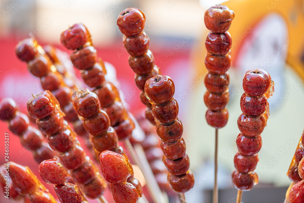 Tanghulu traditional Chinese hard caramel coated fruit skewers close-up ...