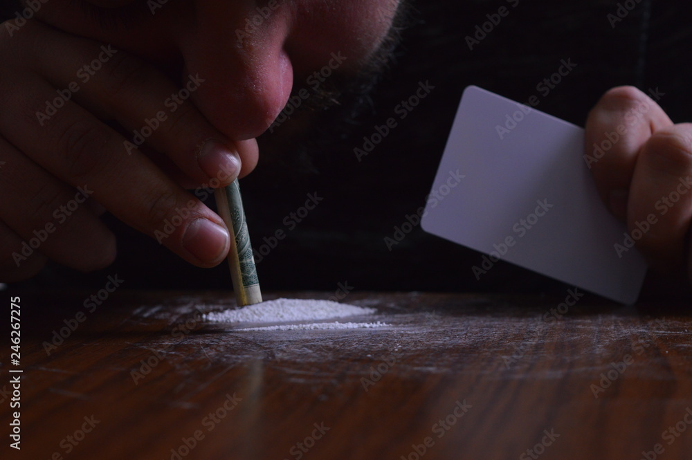Person with a dollar bill snorting cocaine Stock Photo | Adobe Stock