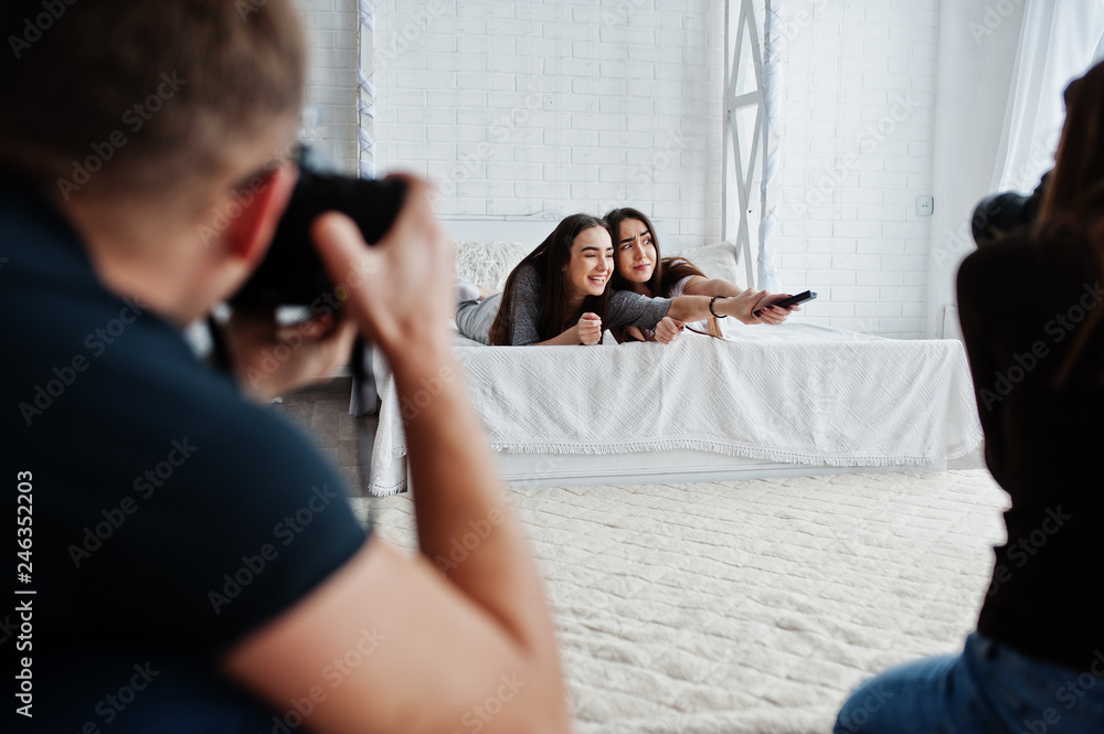 The team of two photographers shooting twins models girls while they ...