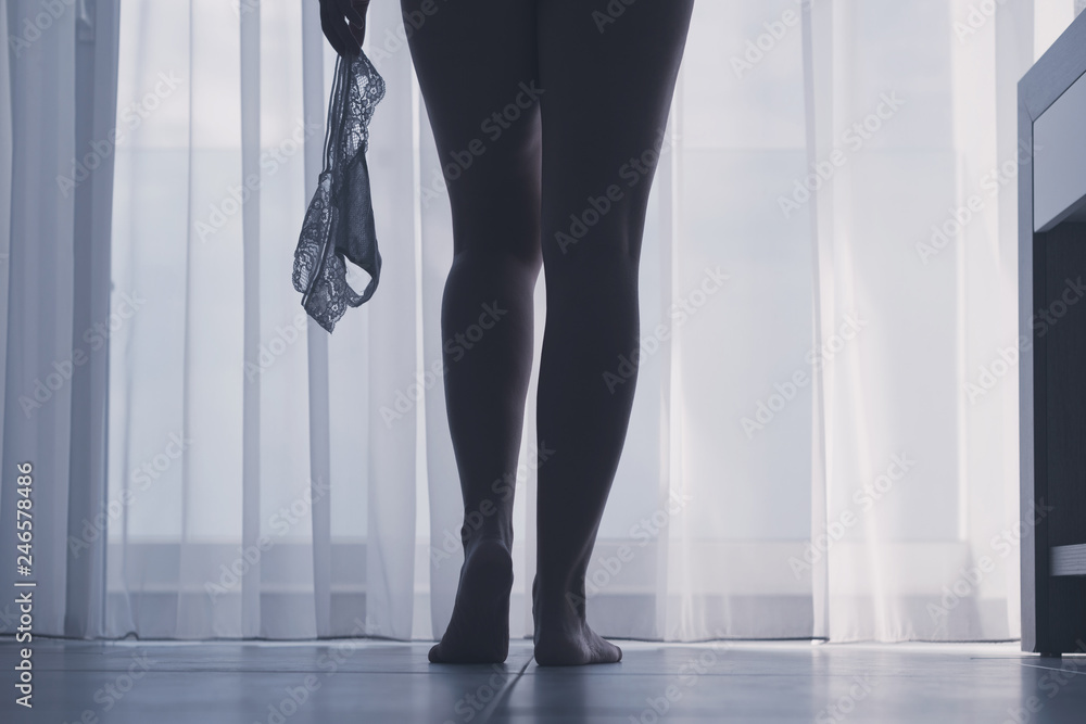 Stock-Foto „Bottom view of silhouette of beautiful woman with sexy legs taking off her white ...