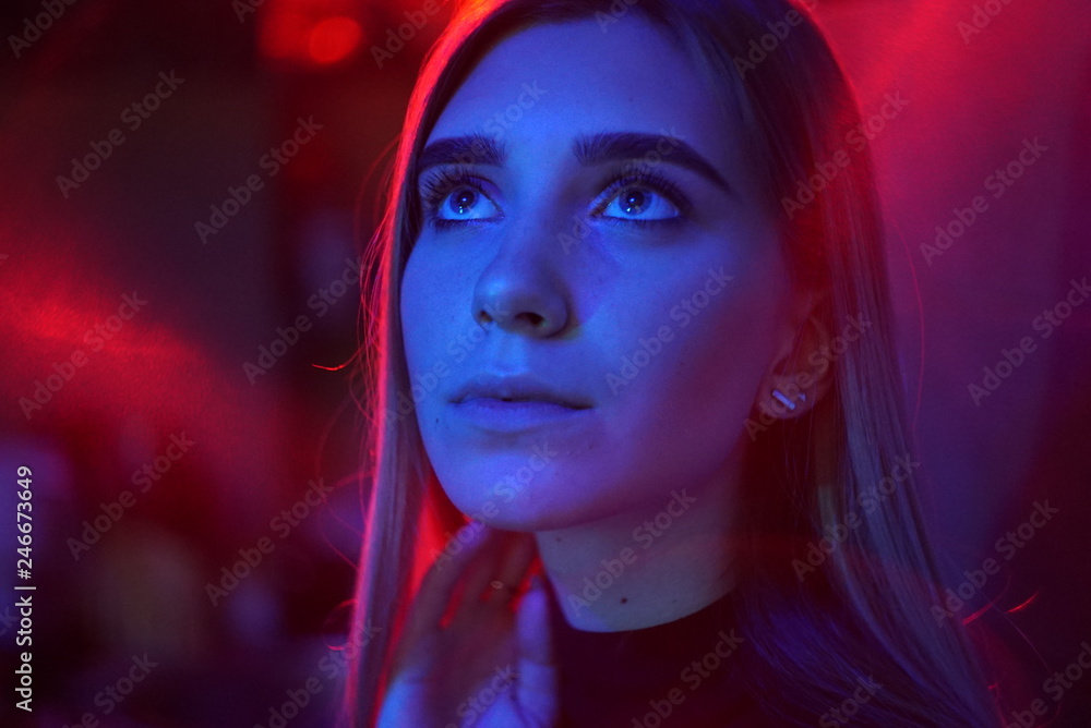 Sexy young beauty woman posing over night city dramatic red and blue ...