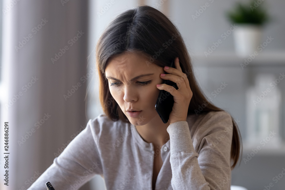 Serious concerned woman talking on phone helping solving problem ...