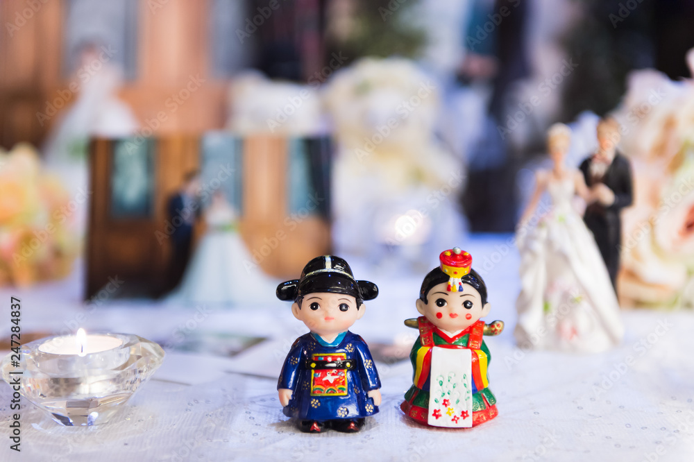 Both bride and bridegroom are standing side by side. They wear wedding ...