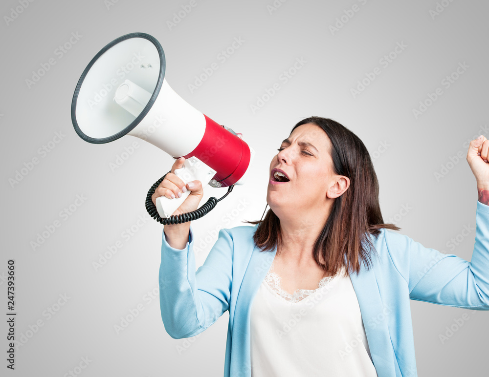 Middle aged woman excited and euphoric, shouting with a megaphone, sign ...