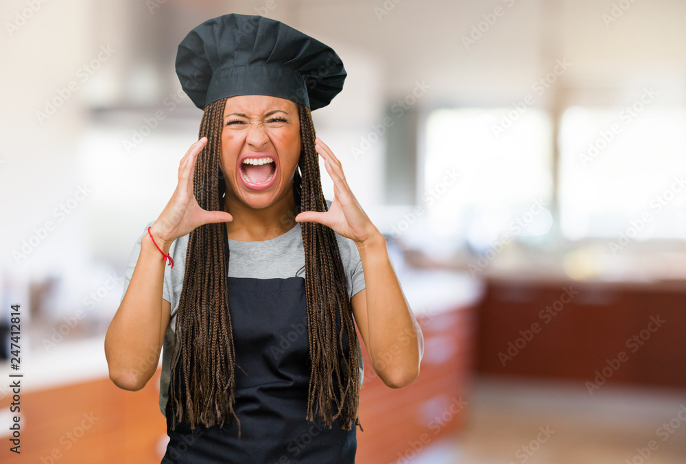 Portrait of a young black baker woman screaming angry, expression of ...