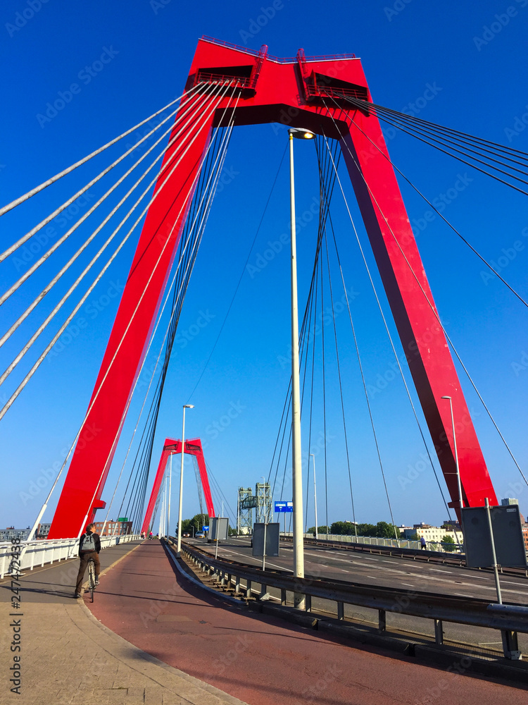 Cyclist crossing the Willemsbrug bridge spanning the Nieuwe Maas river ...