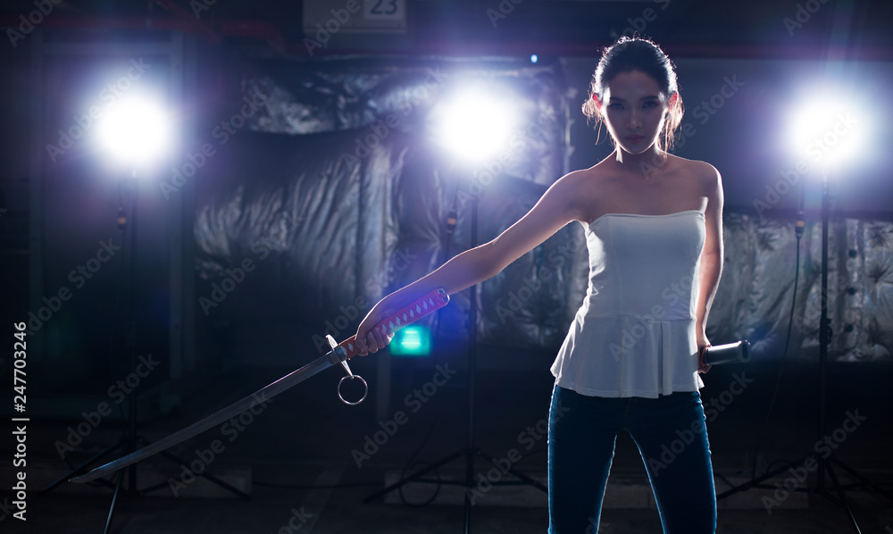 Beautiful Asian Woman demonstrates practice martial art Samurai blade ...