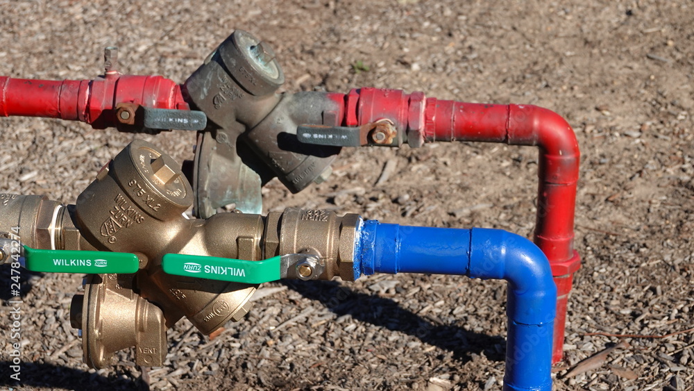 Red and blue water lines with backflow preventer Stock Photo | Adobe Stock