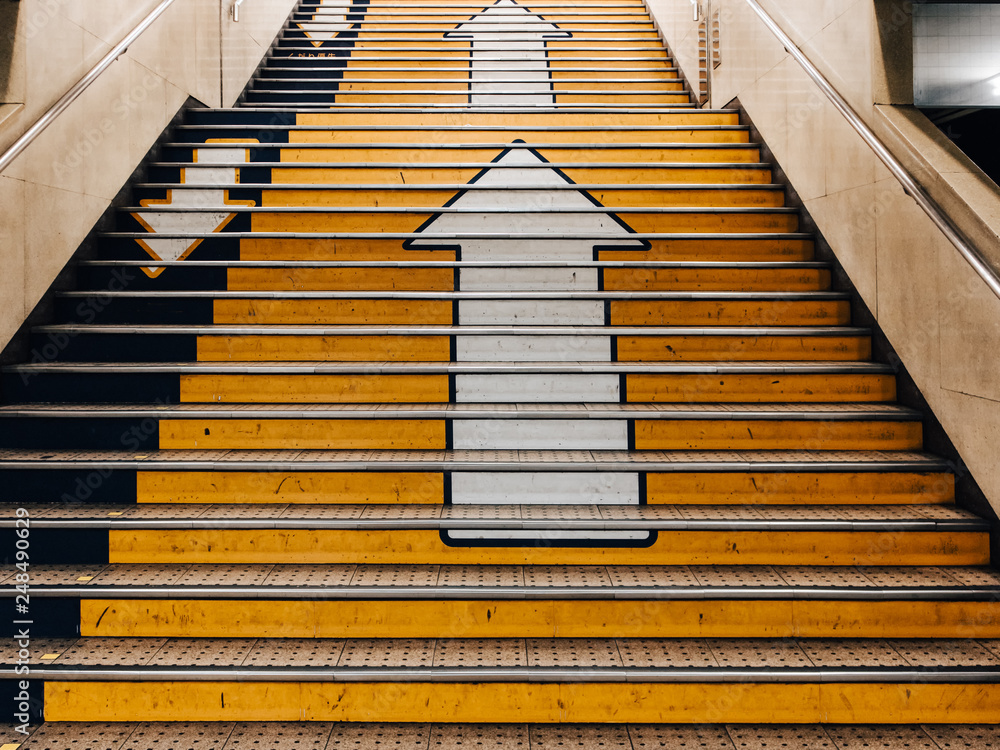 Big arrows direction symbol on concret stair in subway in Japan. there ...