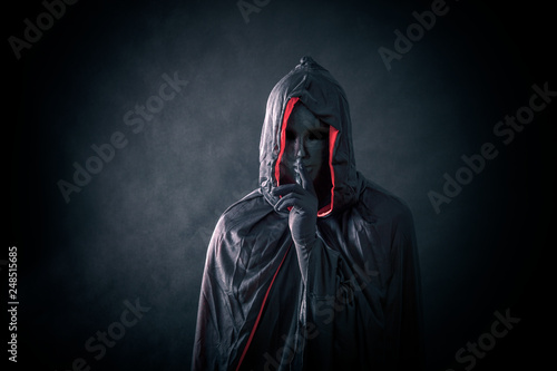 Scary figure with black mask in hooded cloak Stock Photo | Adobe Stock
