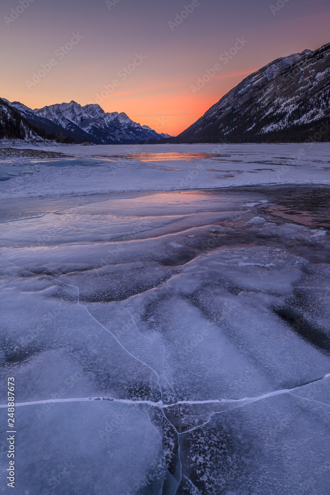 Sunset on a frozen lake in Kananaskis Country in the Canadian Rocky ...
