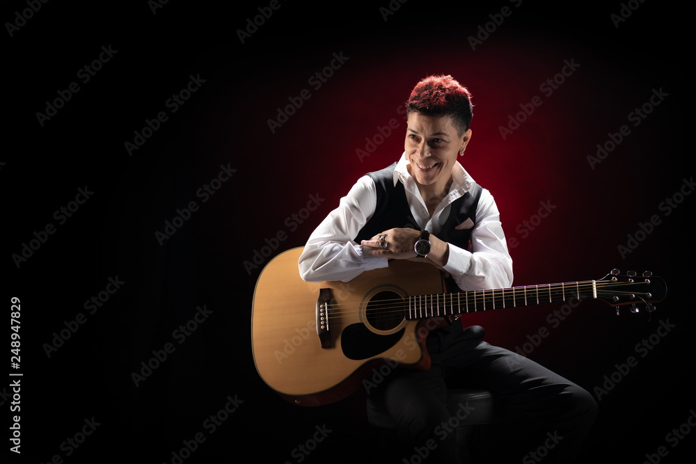 Woman musician with red hair in a black suit and white shirt with a ...