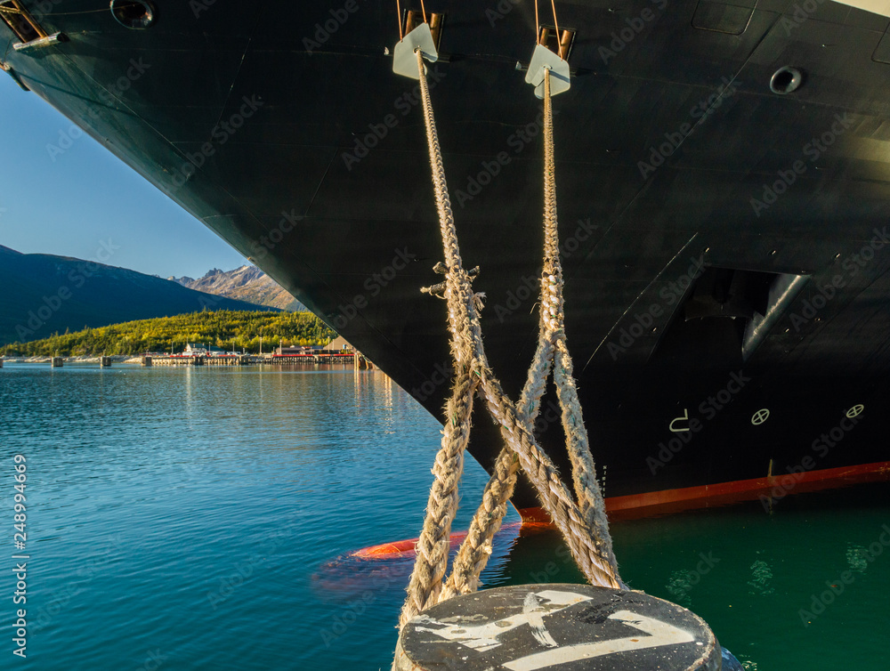 Mooring lines with rat guards from bow of cruise ship, tied to bollard ...