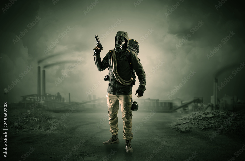Gas masked survival man coming with arms on his hand in a demolished ...