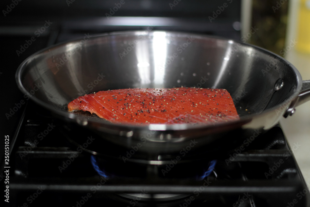 Wild caught Coho salmon frying in a pan with the skin side down. Stock ...
