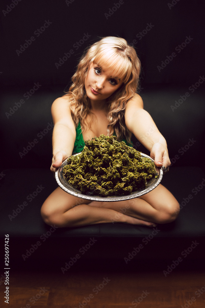 Blonde caucasian woman in cannabis bikini poses with tray of marijuana ...