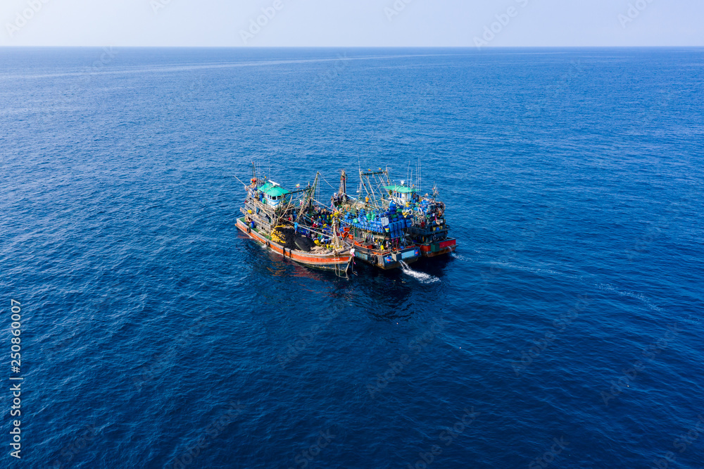 Overfishing - aerial view of a large fleet of fishing trawlers working ...