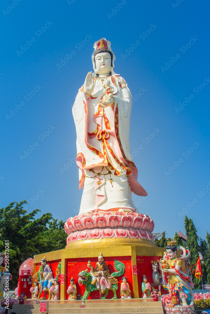 Giant white Guanyin statue with blue sky background. Guanyin or Guan ...